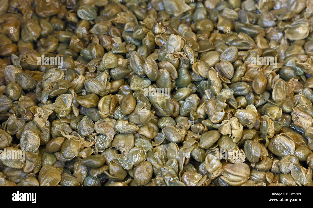 Green pickled small capers close up background Stock Photo - Alamy