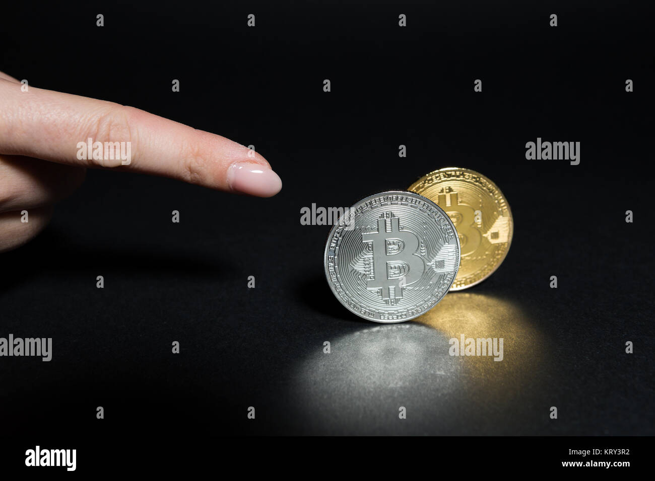 Finger pointing bitcoins on dark background as virtual financial growth ...
