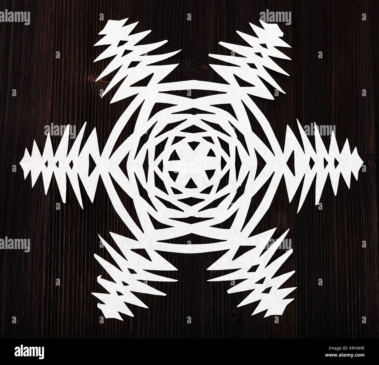 snowflake carved from paper on dark brown board Stock Photo - Alamy