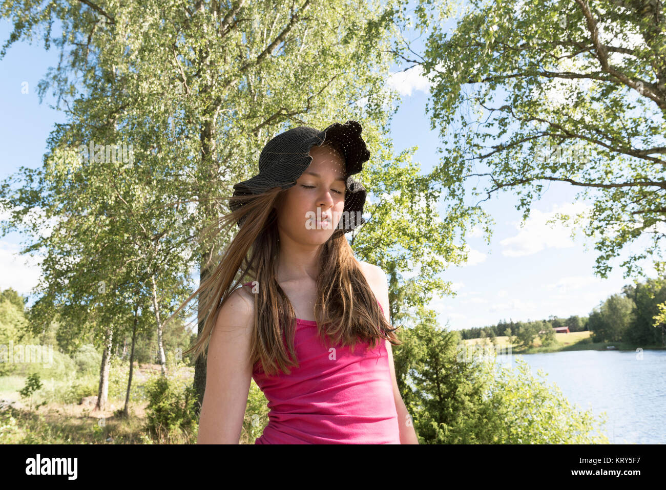 A girl standing under trees beside a river Stock Photo - Alamy
