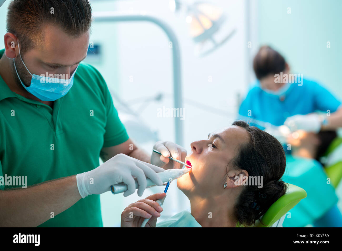 Dentist examining a patient's teeth in the dentist Stock Photo - Alamy