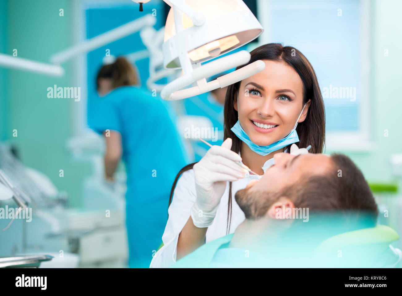 Dentist examining a patient's teeth in the dentist Stock Photo - Alamy