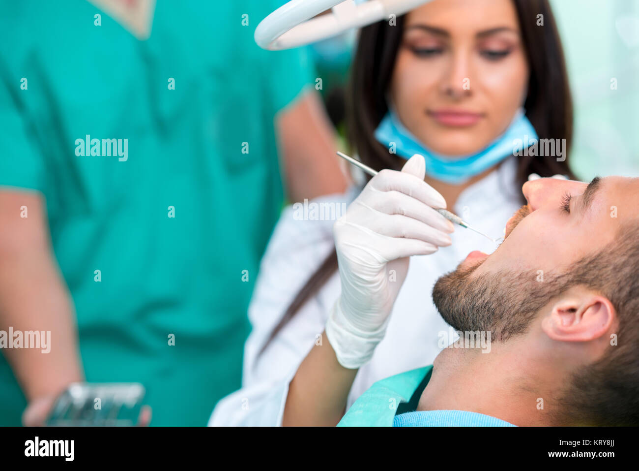 Dentist examining a patient's teeth in the dentist Stock Photo - Alamy
