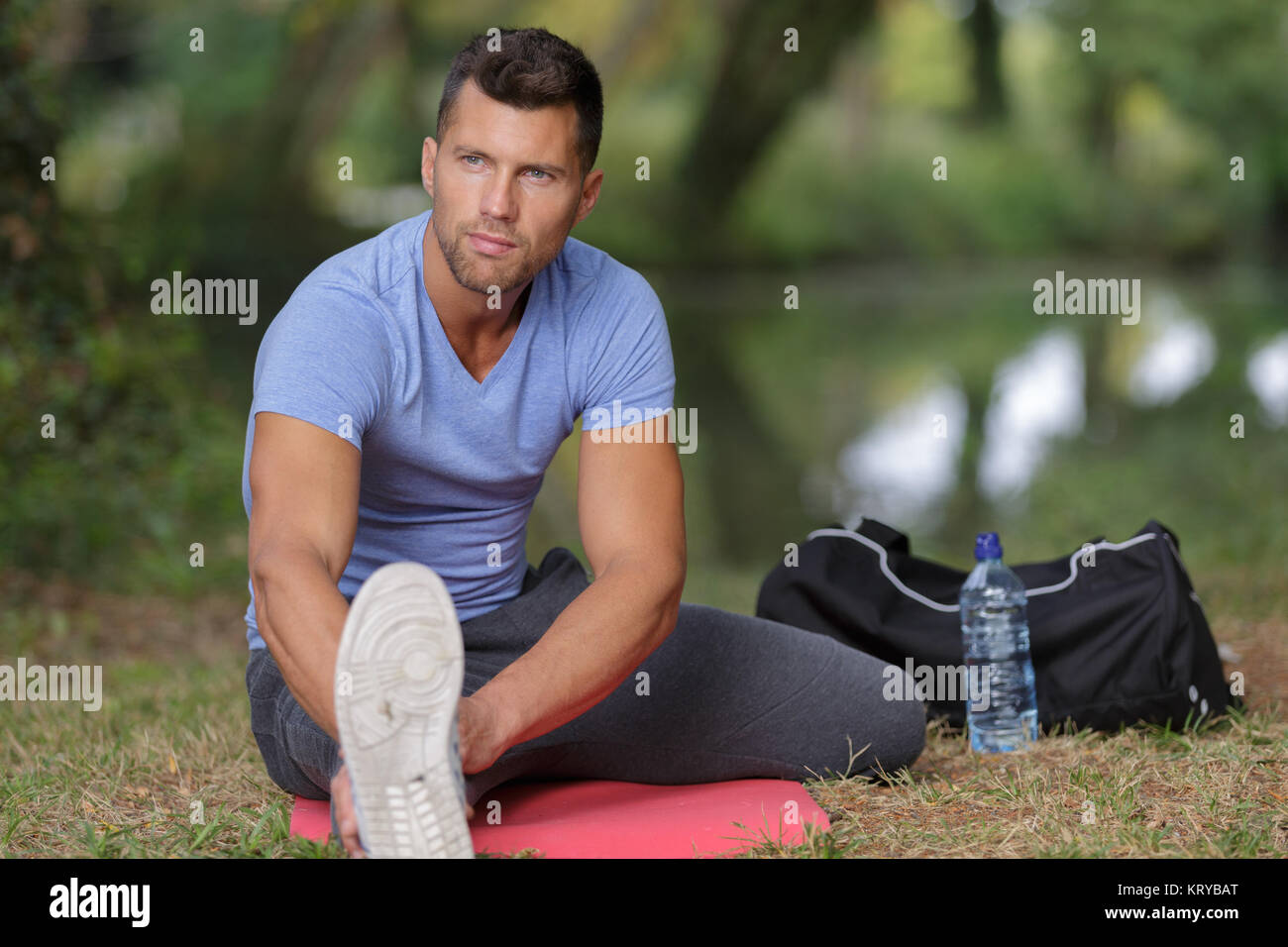 handsome young man stretching at the park Stock Photo - Alamy