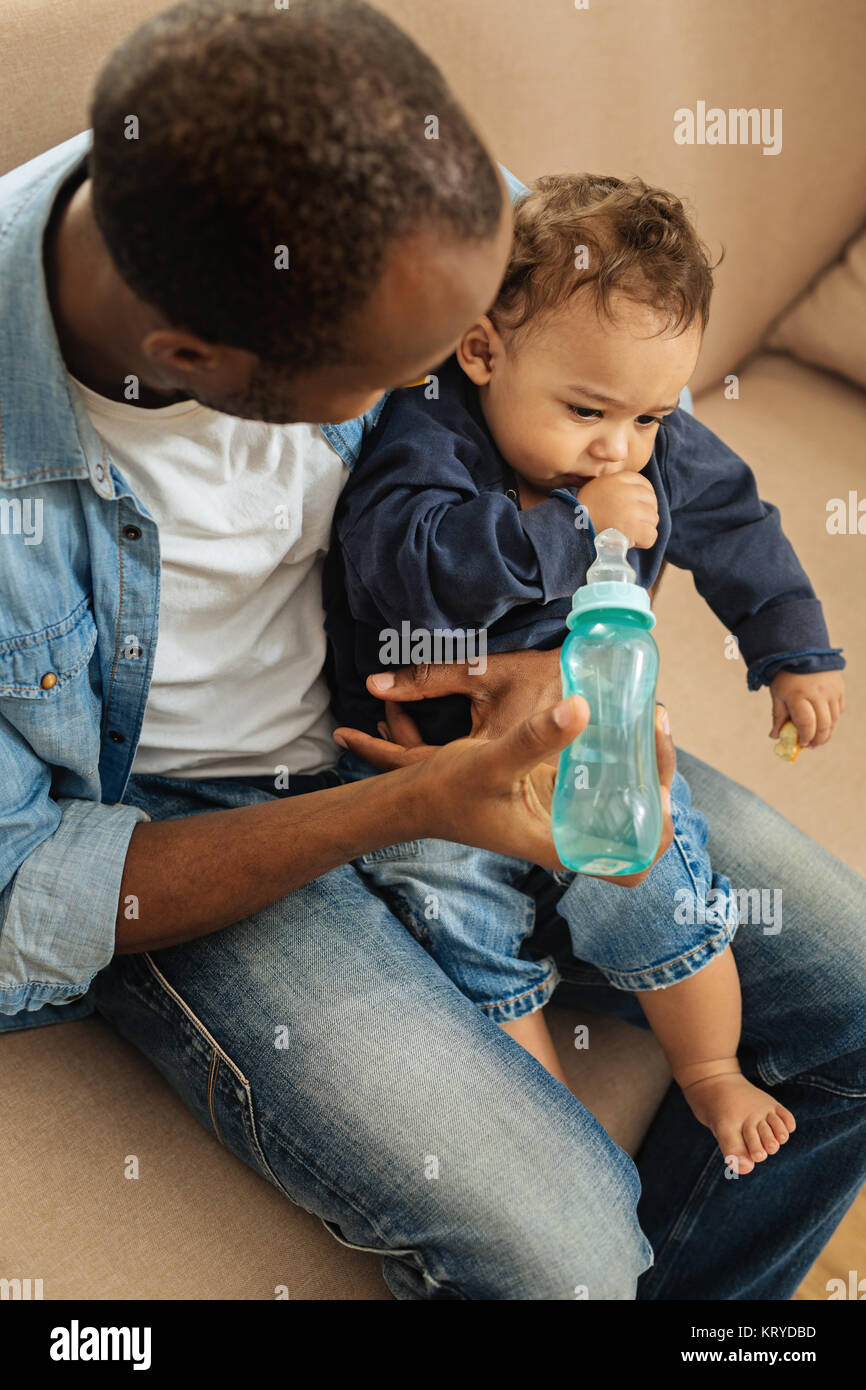 Loving daddy feeding his little son Stock Photo - Alamy