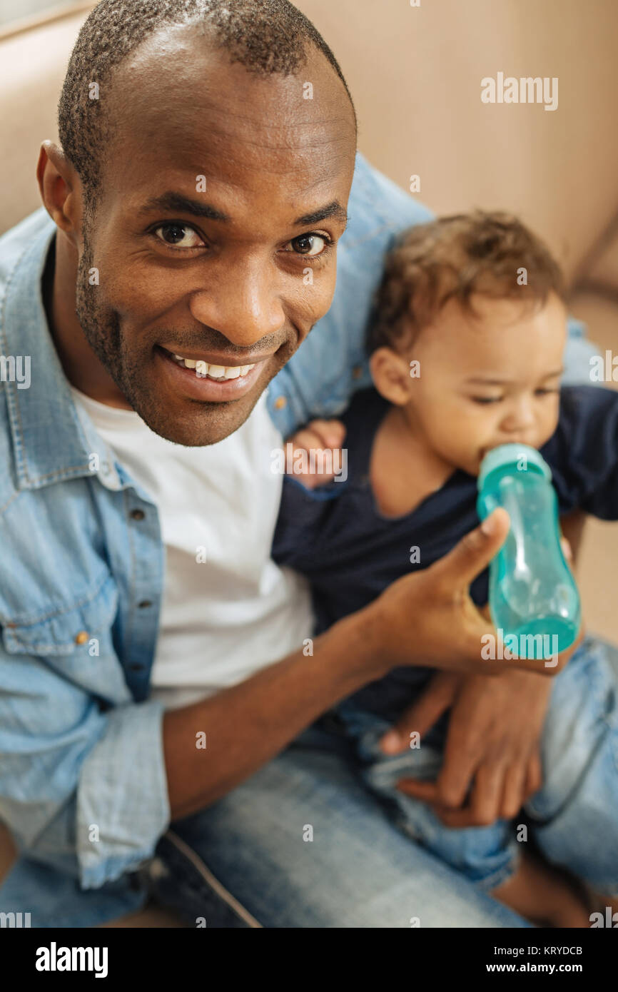 Smiling daddy feeding his child Stock Photo - Alamy