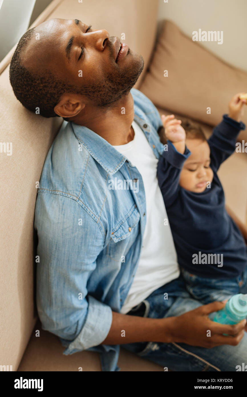 Tired father sleeping and holding his baby Stock Photo - Alamy