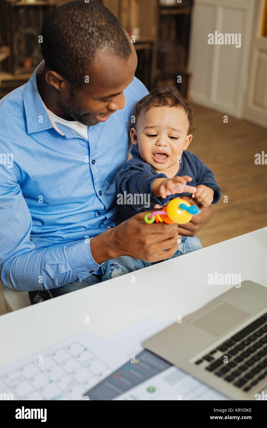 Smiling daddy holding his baby and toy Stock Photo - Alamy