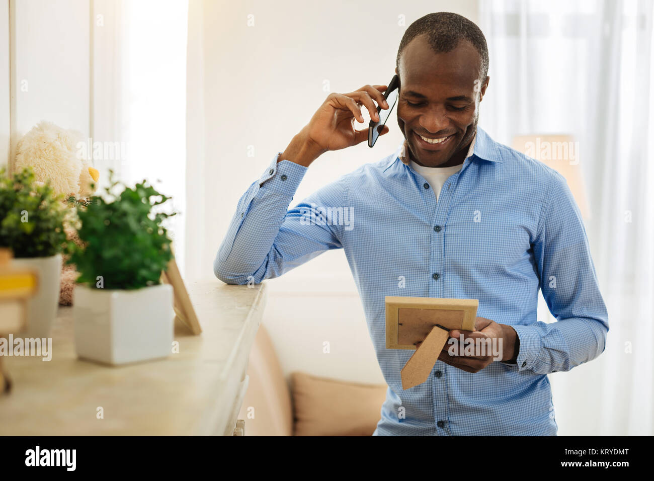 Exuberant man talking on the phone and holding a picture Stock Photo ...