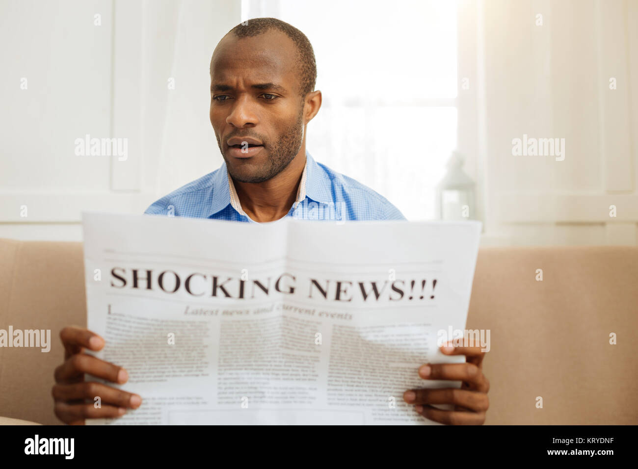 Baffled man reading shocking news Stock Photo - Alamy