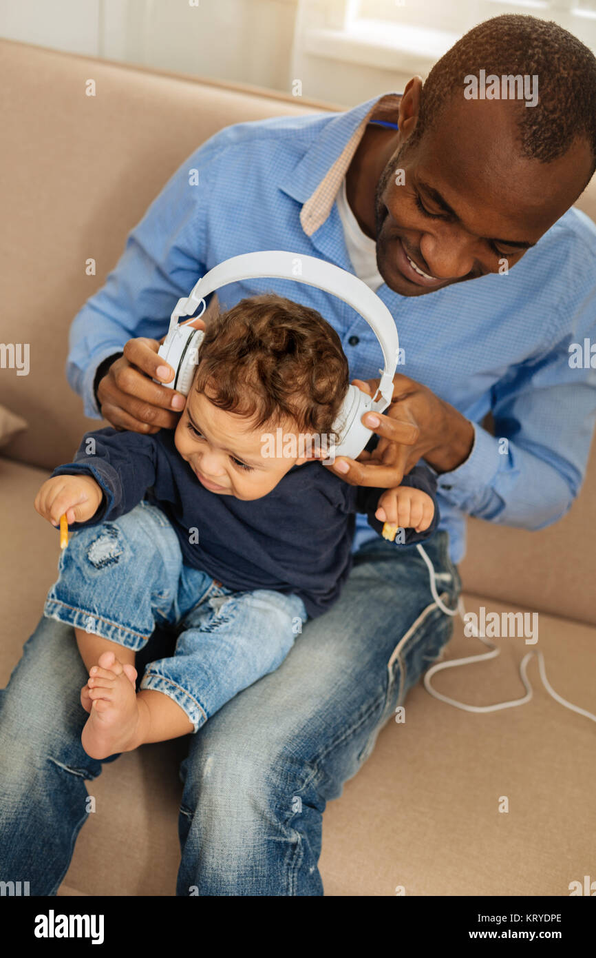 Smiling father listening to music with his baby Stock Photo - Alamy