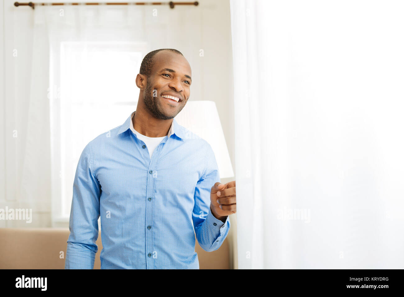 Happy man looking out the window Stock Photo - Alamy