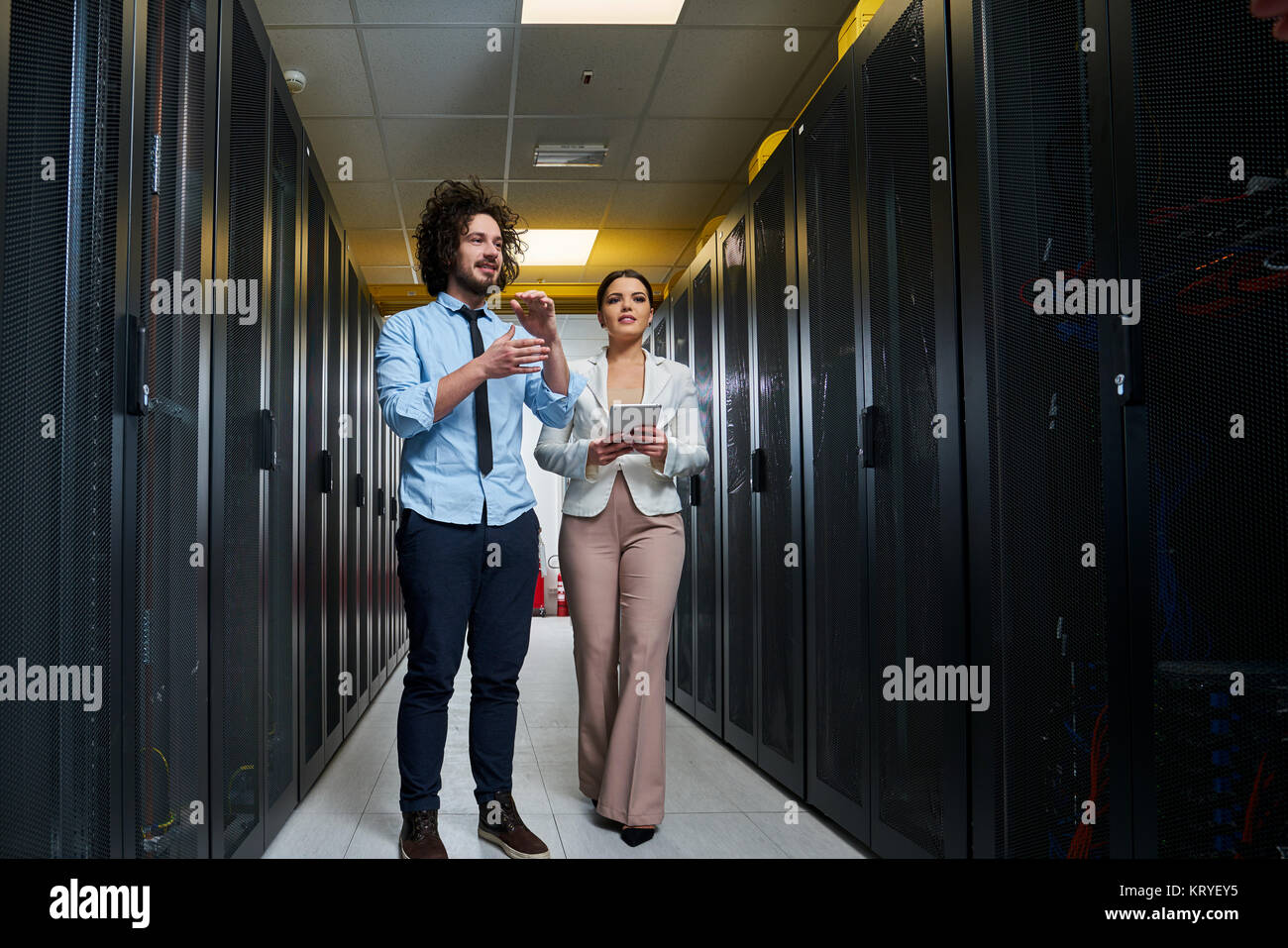Young couple working at a data center. Black server room Stock Photo ...