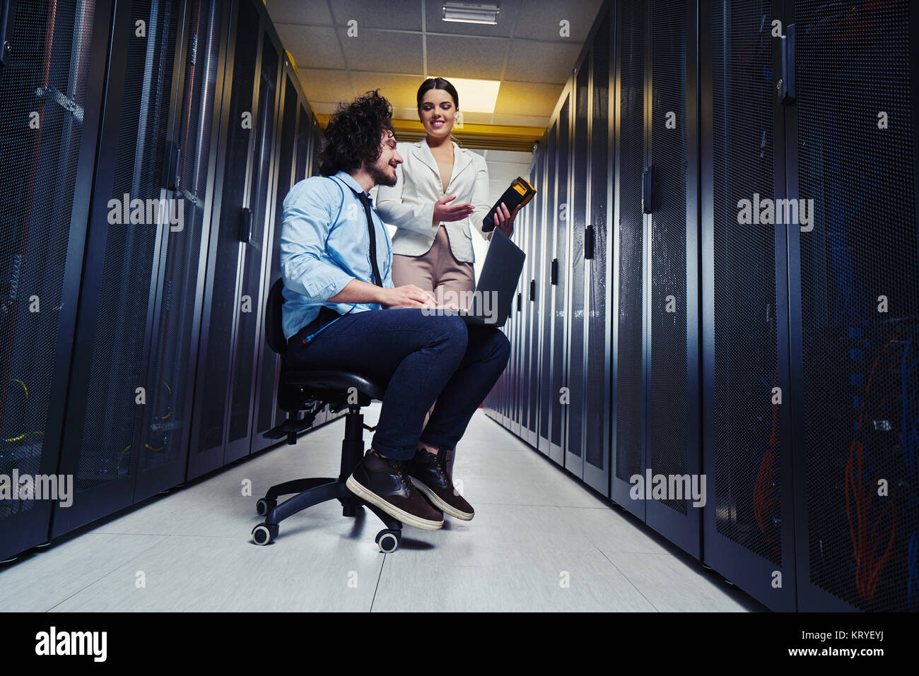 two young technicians working at a data center on server maintenance ...