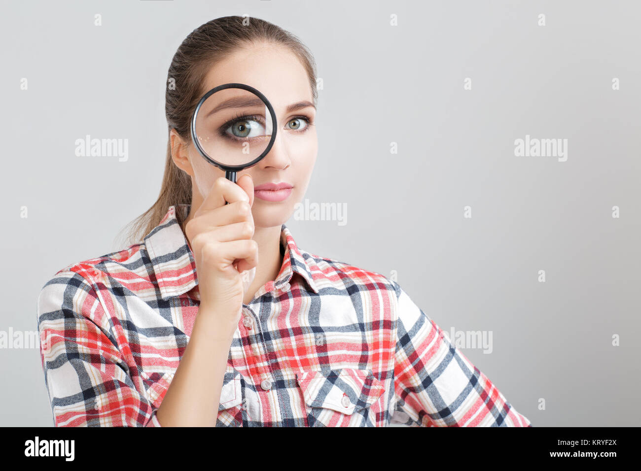 woman looks through a magnifying glass Stock Photo - Alamy