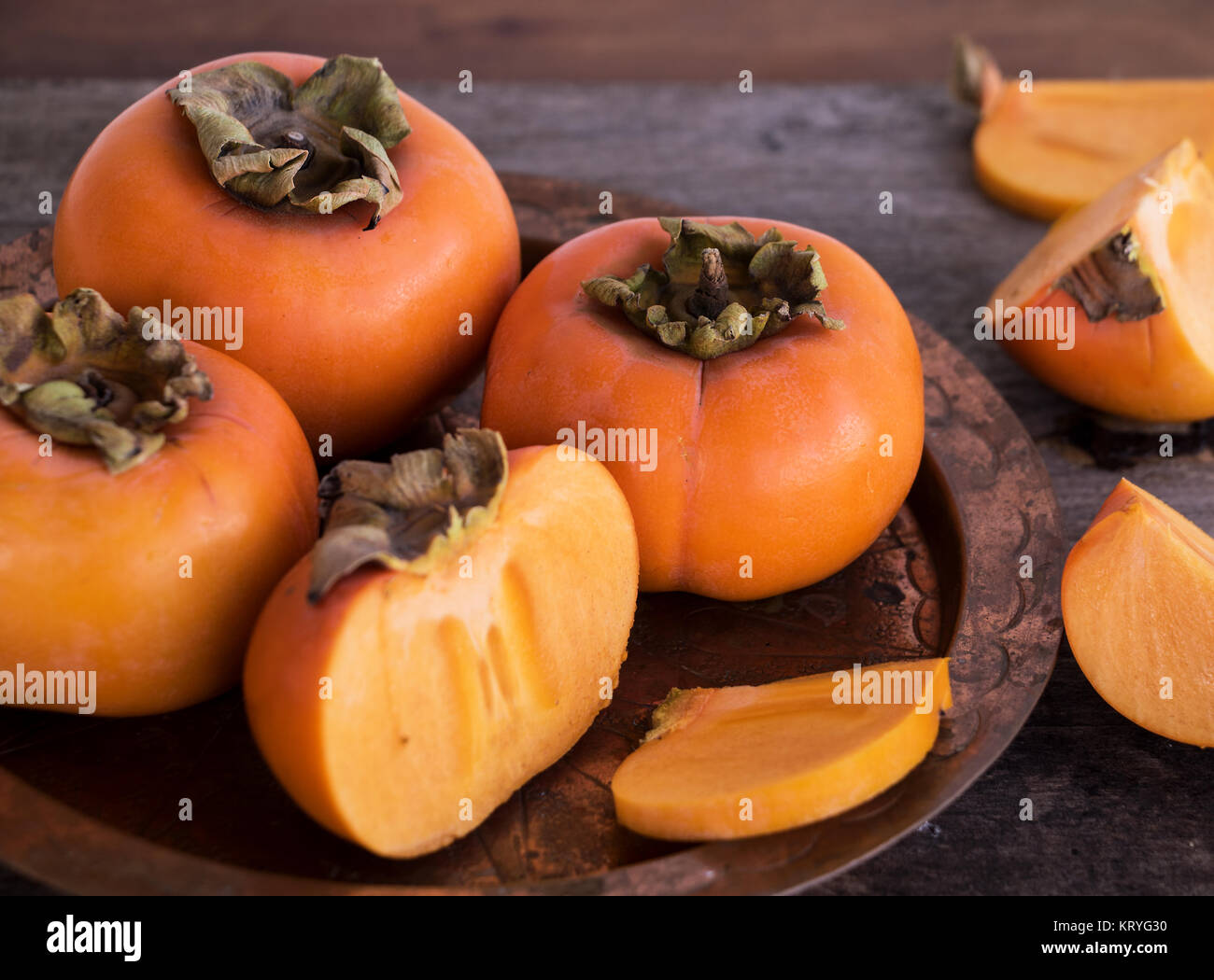 fresh persimmons on copper plate Stock Photo - Alamy