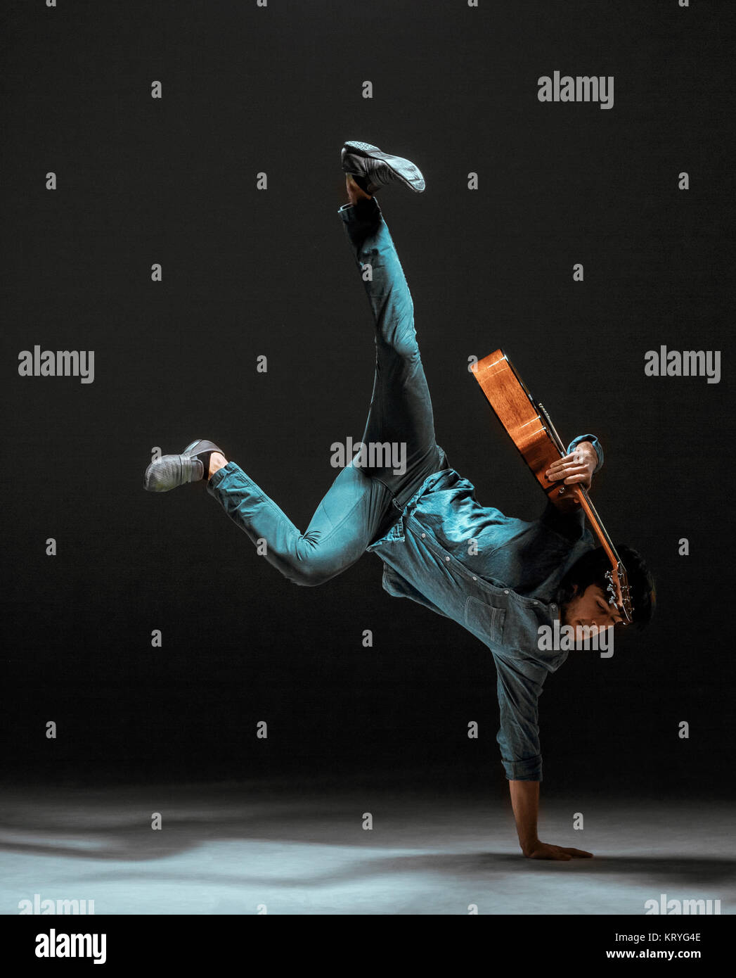 Cool guy standing with guitar on dark background Stock Photo - Alamy