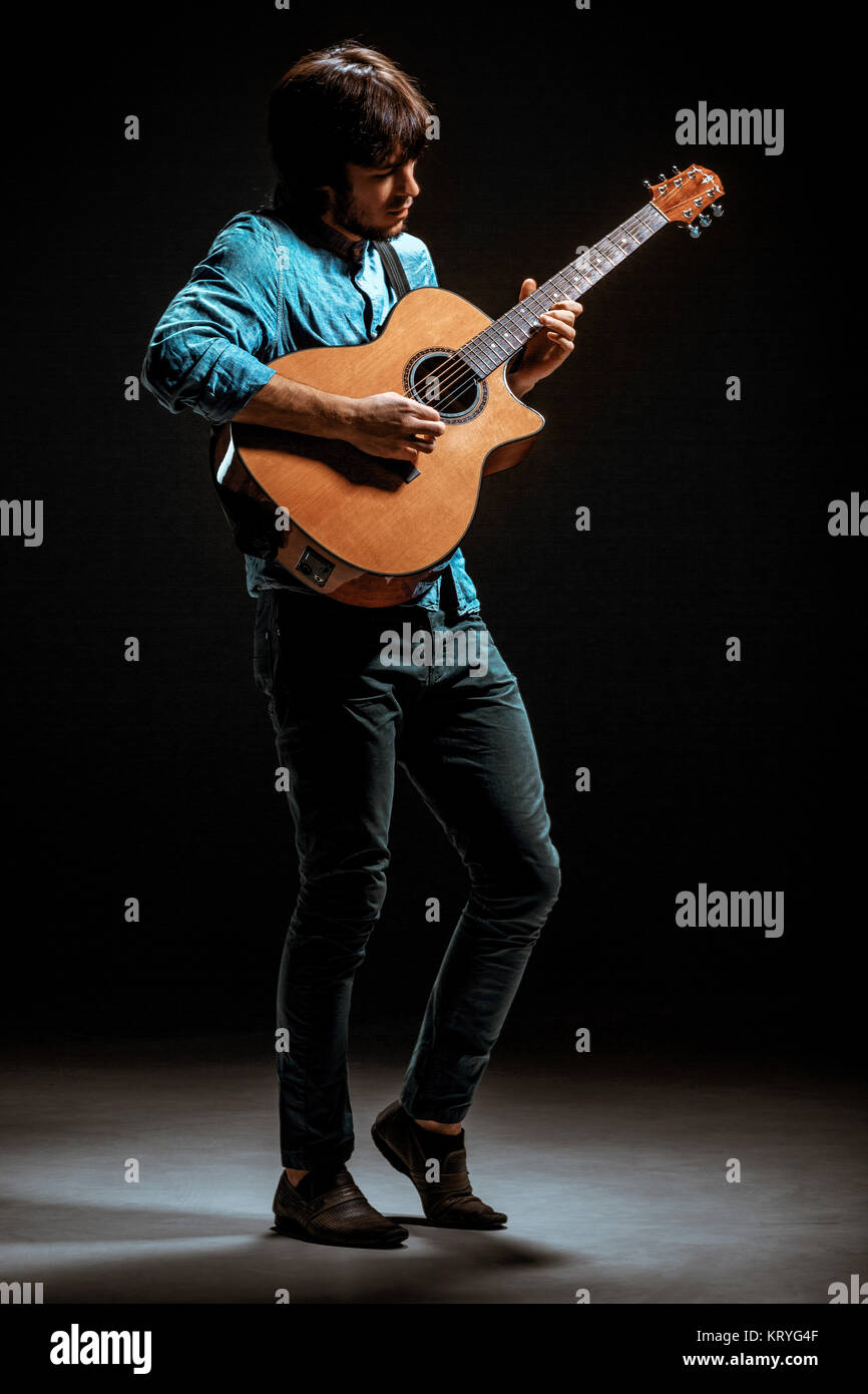 Cool guy standing with guitar on dark background Stock Photo - Alamy