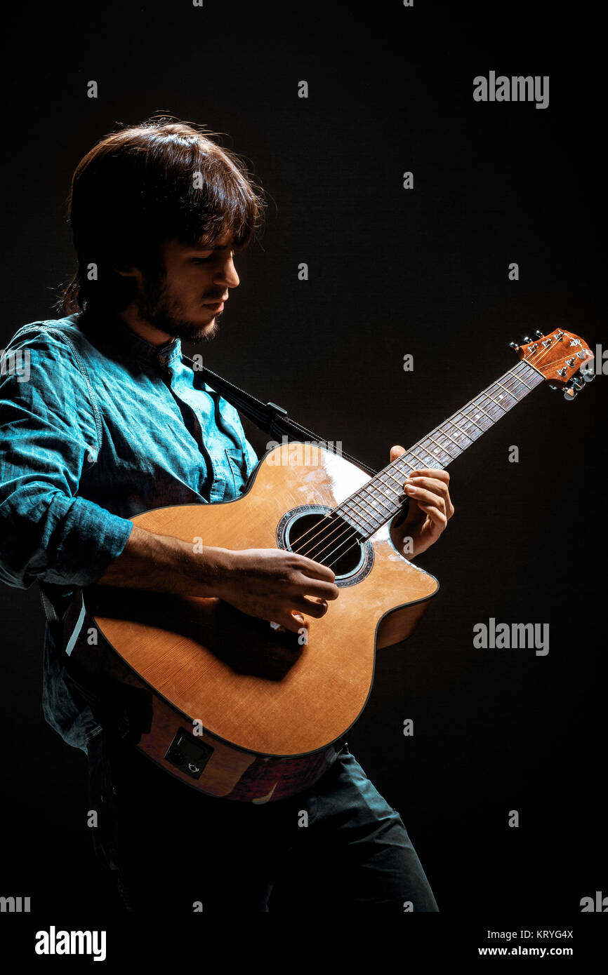 Cool guy standing with guitar on dark background Stock Photo - Alamy