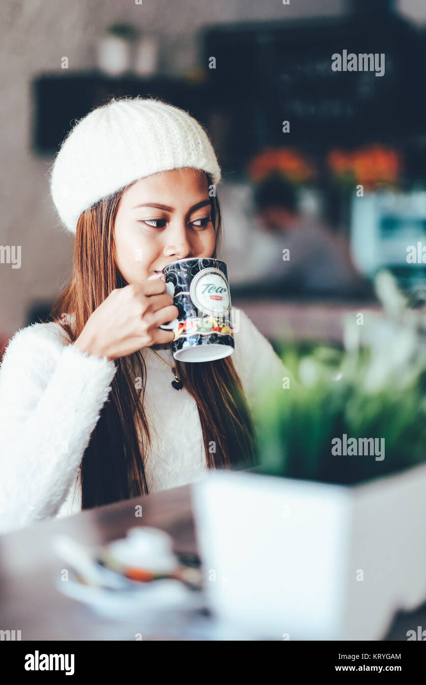 girl enjoying drinking tea in a cafe Stock Photo - Alamy