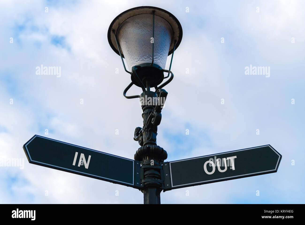 IN versus OUT directional signs on guidepost Stock Photo - Alamy