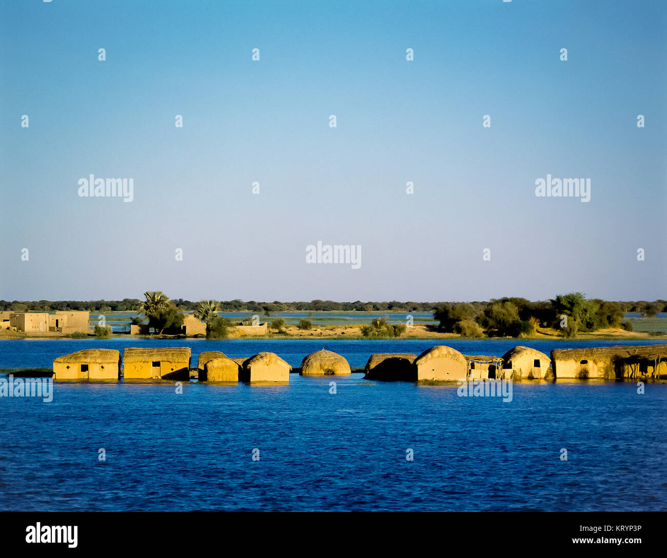 View of a village by the Niger river and adobe buildings, Mali Stock ...