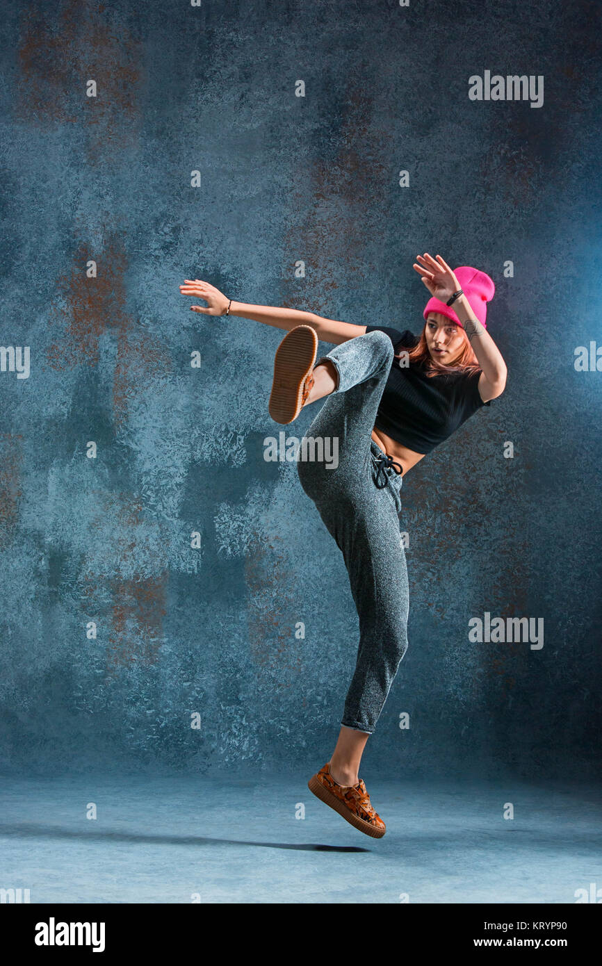 Young girl break dancing on blue studio background Stock Photo - Alamy