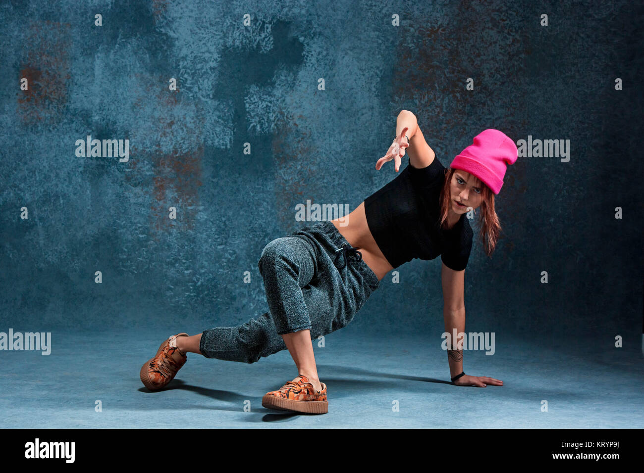 Young girl break dancing on blue studio background Stock Photo - Alamy