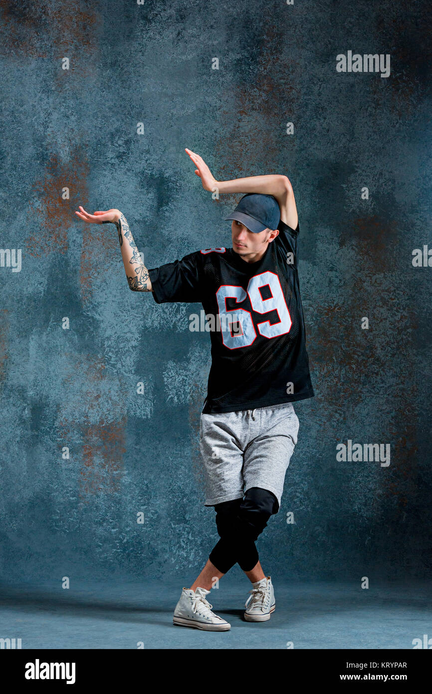 Young man break dancing on blue studio background Stock Photo - Alamy