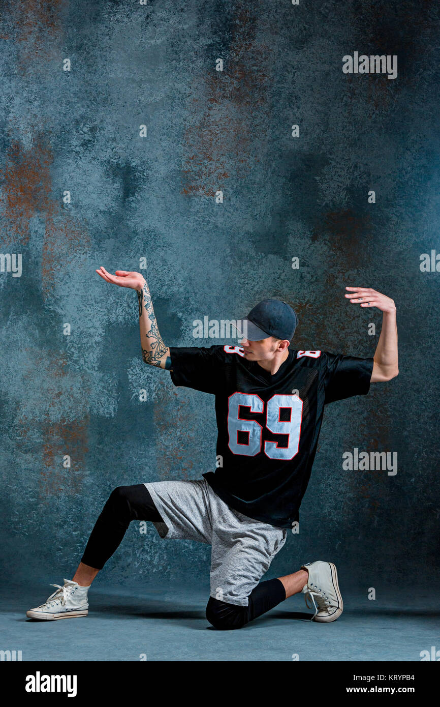 Young man break dancing on blue studio background Stock Photo - Alamy
