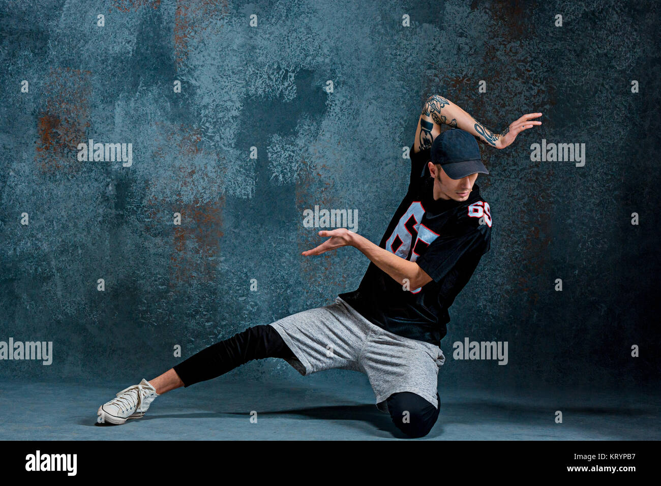 Young man break dancing on blue studio background Stock Photo - Alamy