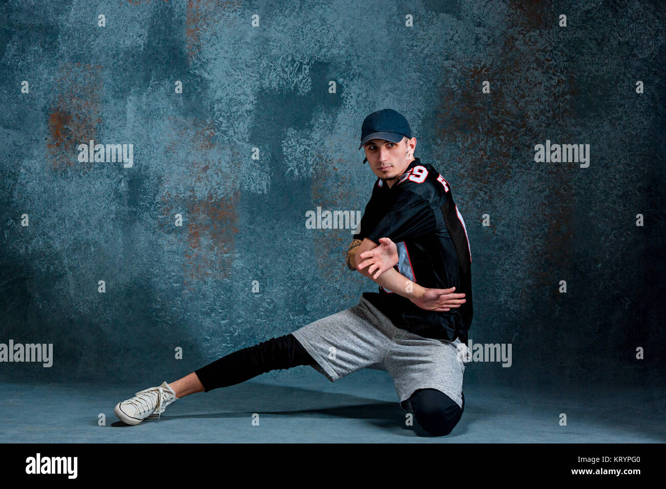 Young man break dancing on wall background Stock Photo - Alamy