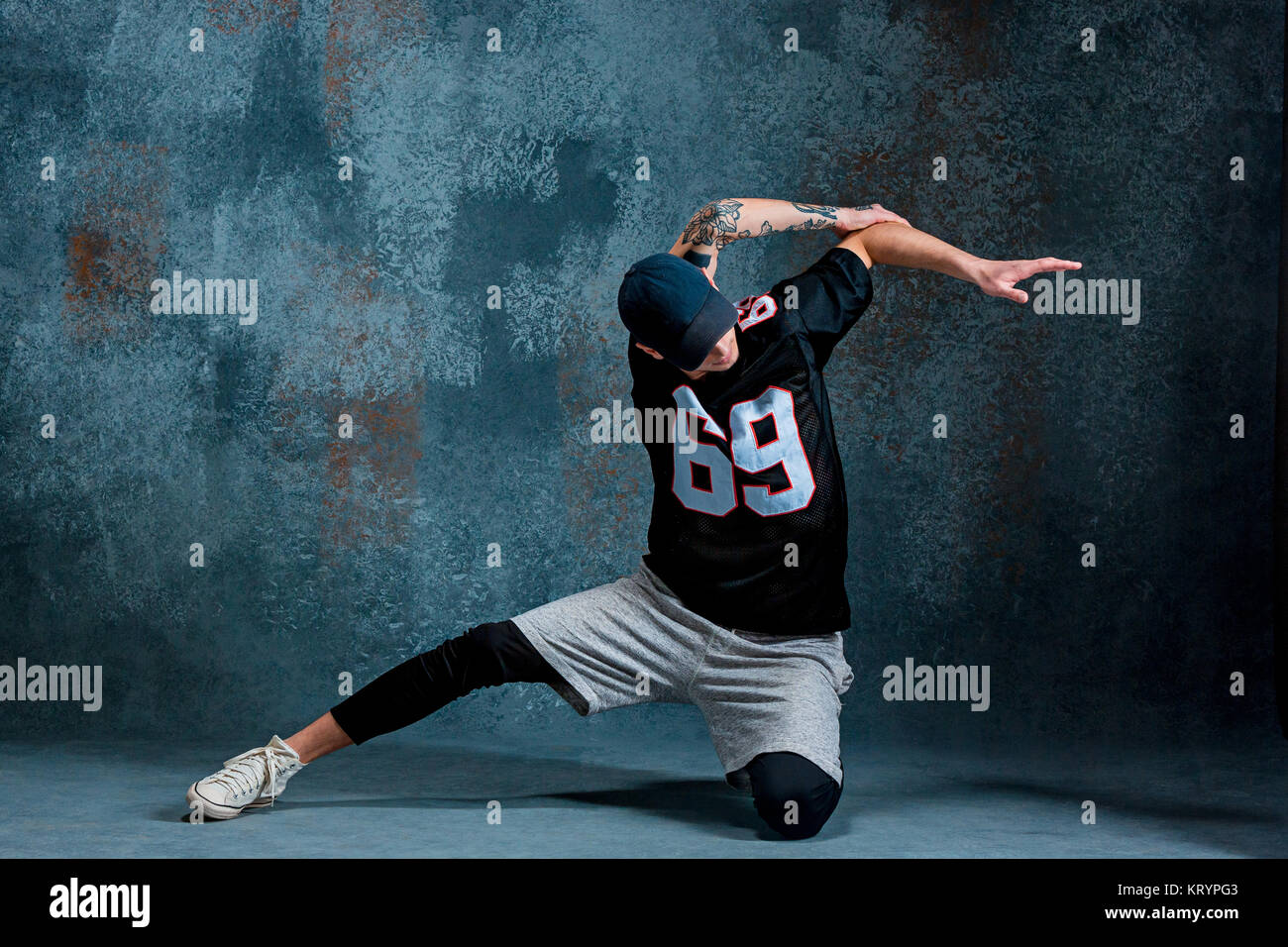 Young man break dancing on wall background Stock Photo - Alamy