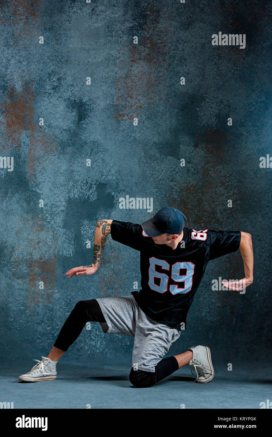 Young man break dancing on wall background Stock Photo - Alamy