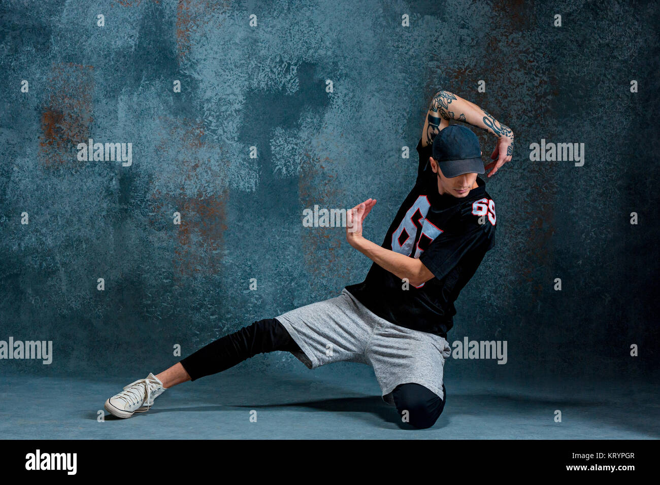 Young man break dancing on wall background Stock Photo - Alamy