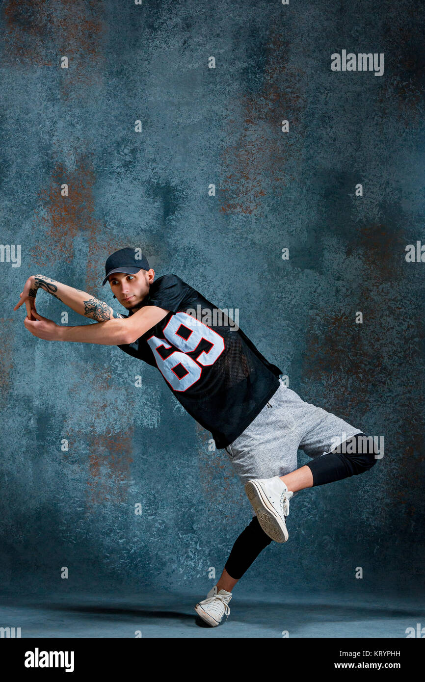 Young man break dancing on wall background Stock Photo - Alamy