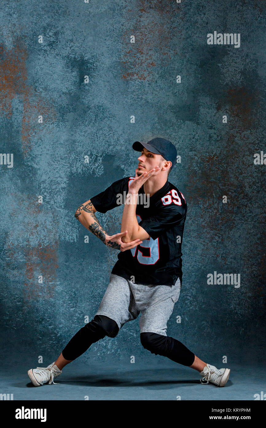 Young man break dancing on wall background Stock Photo - Alamy