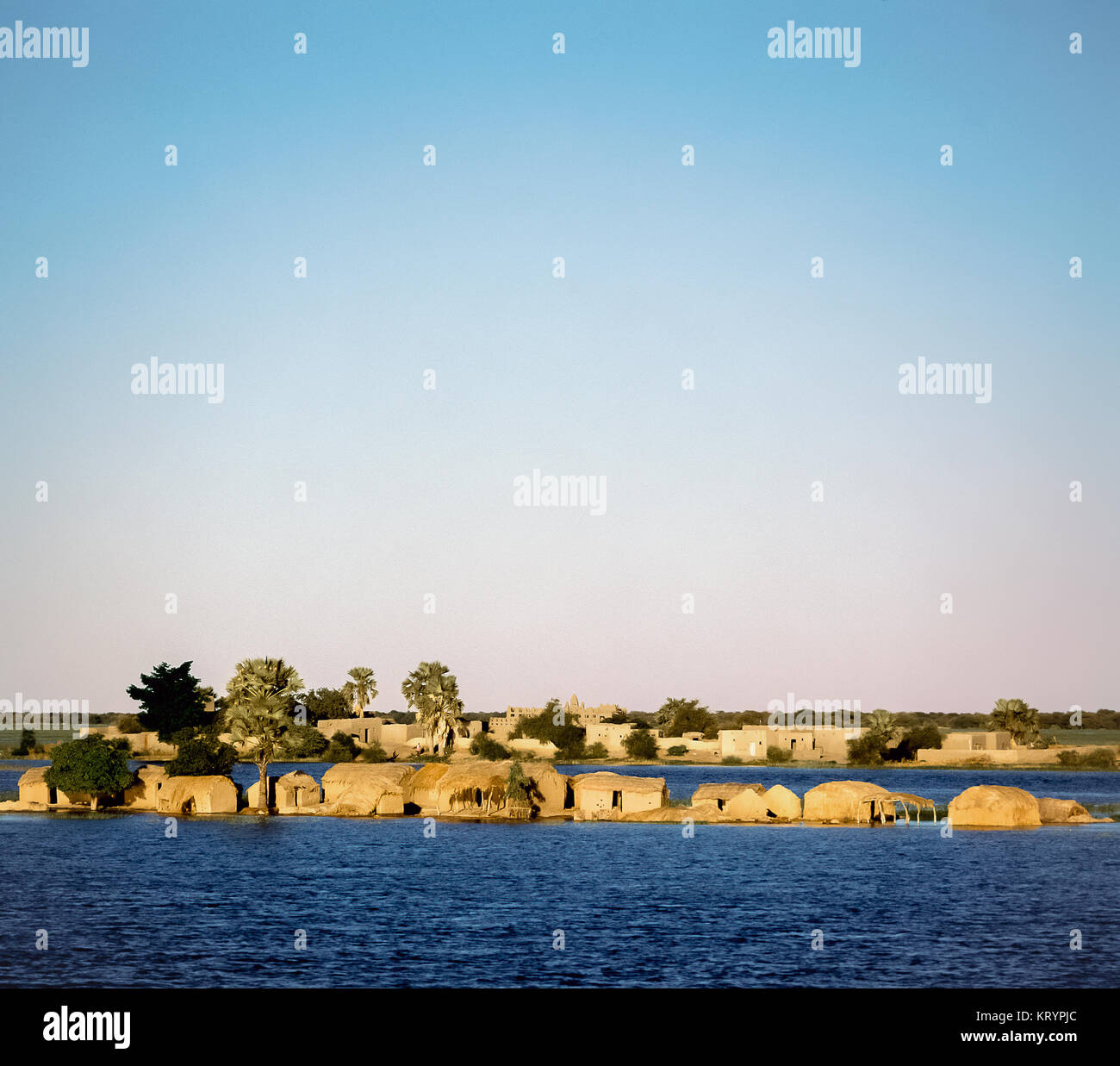 View of a village by the Niger river and adobe buildings, Mali Stock ...