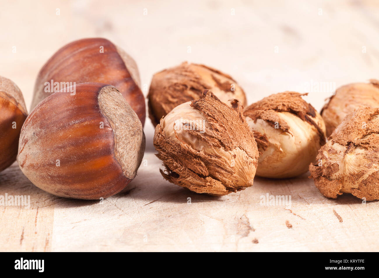 Composition of hazelnuts wooden plank, close up Stock Photo - Alamy