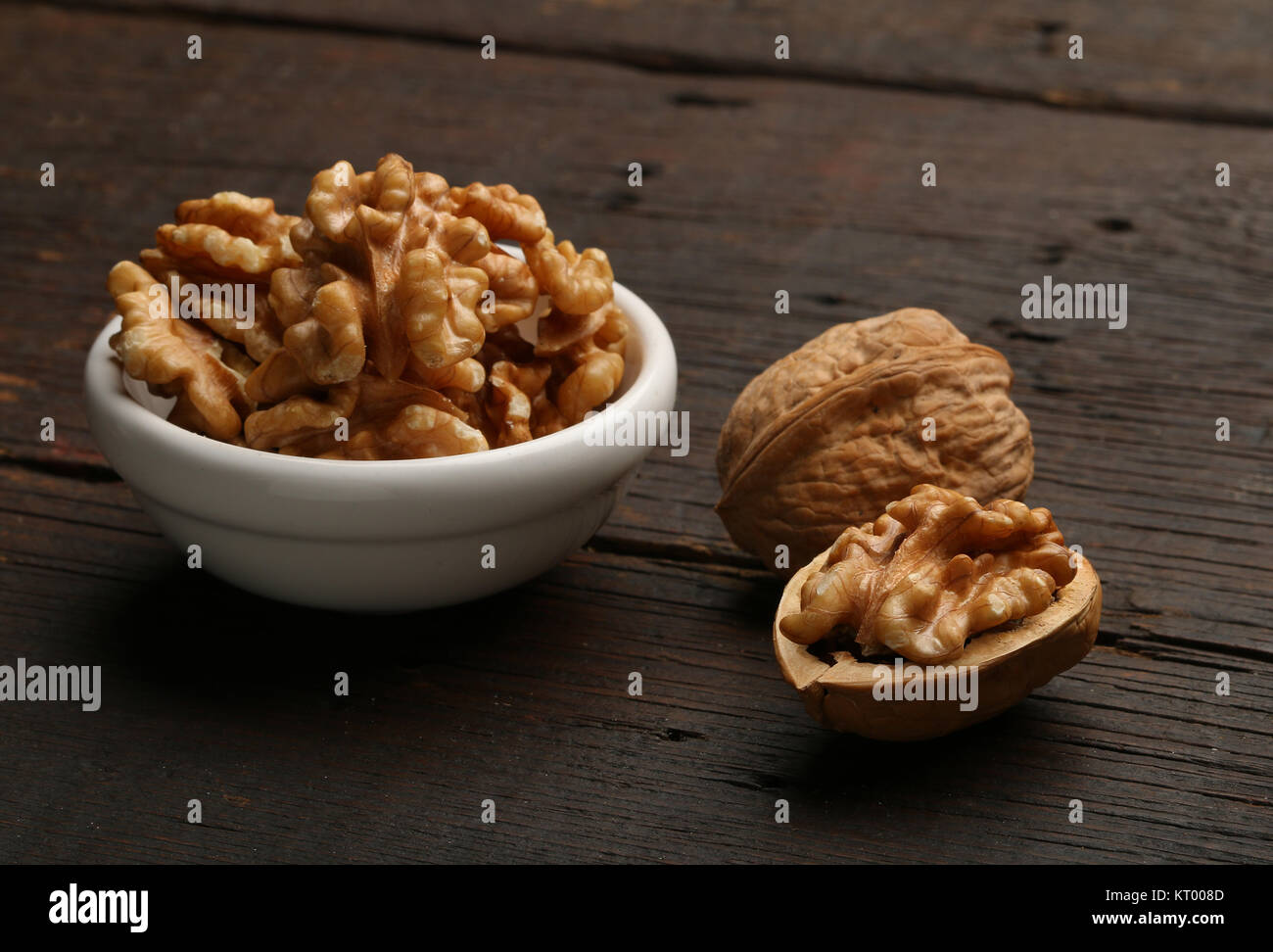 Group of nuts in a bowl, over a wooden background Stock Photo - Alamy