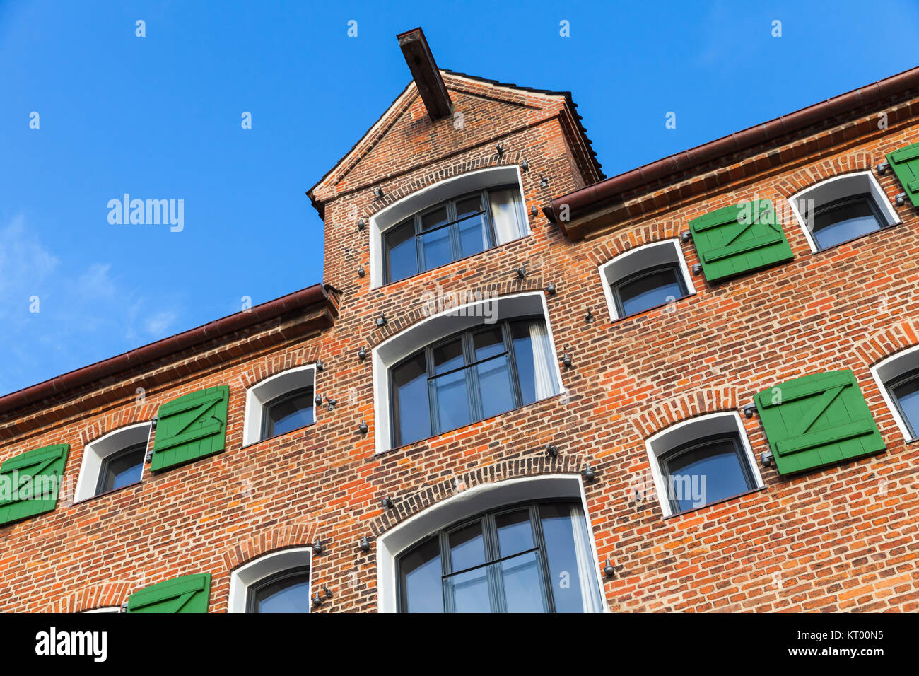 Old house facade, red brick wall with windows and crane beam ...
