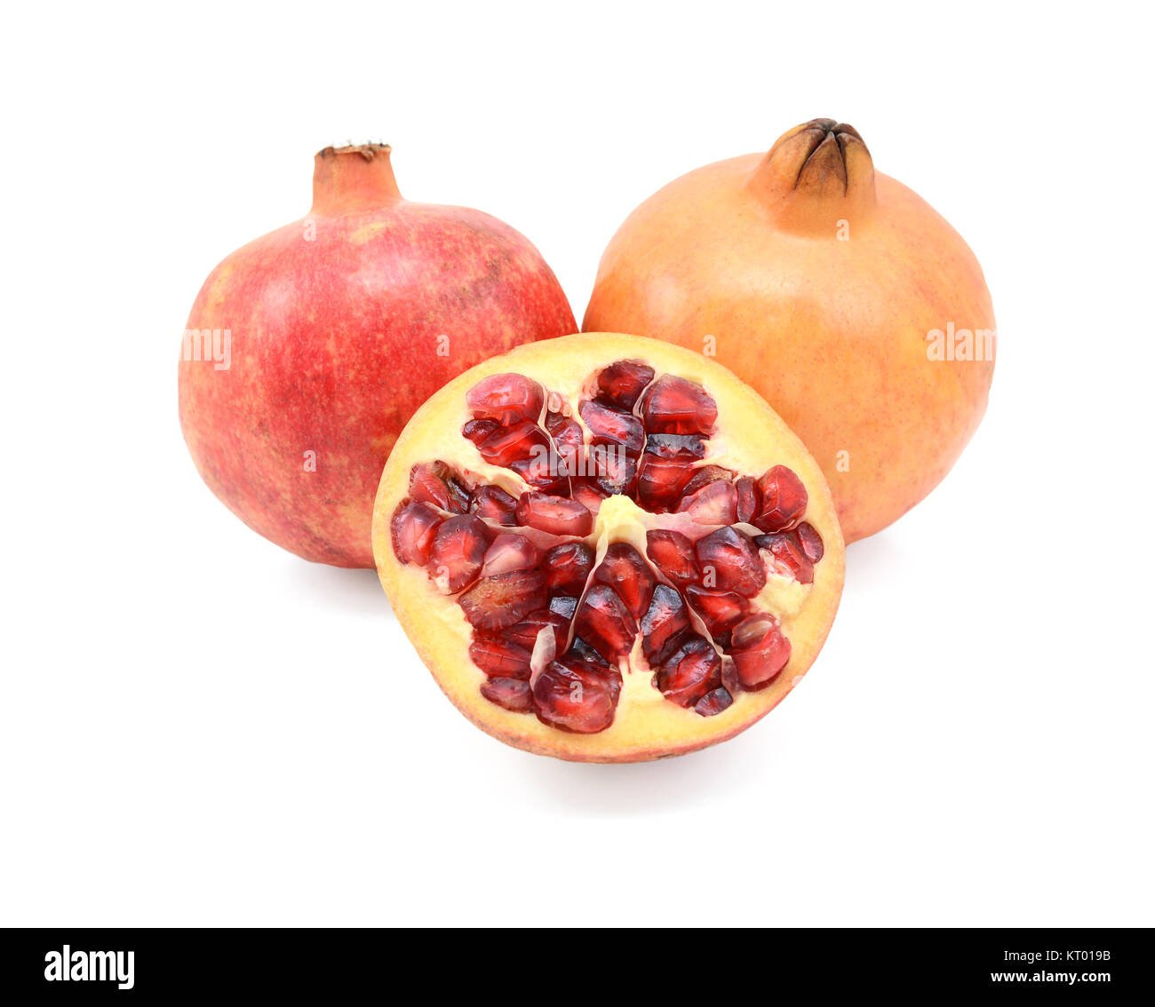 Two pomegranates and a cut half showing seeds Stock Photo - Alamy