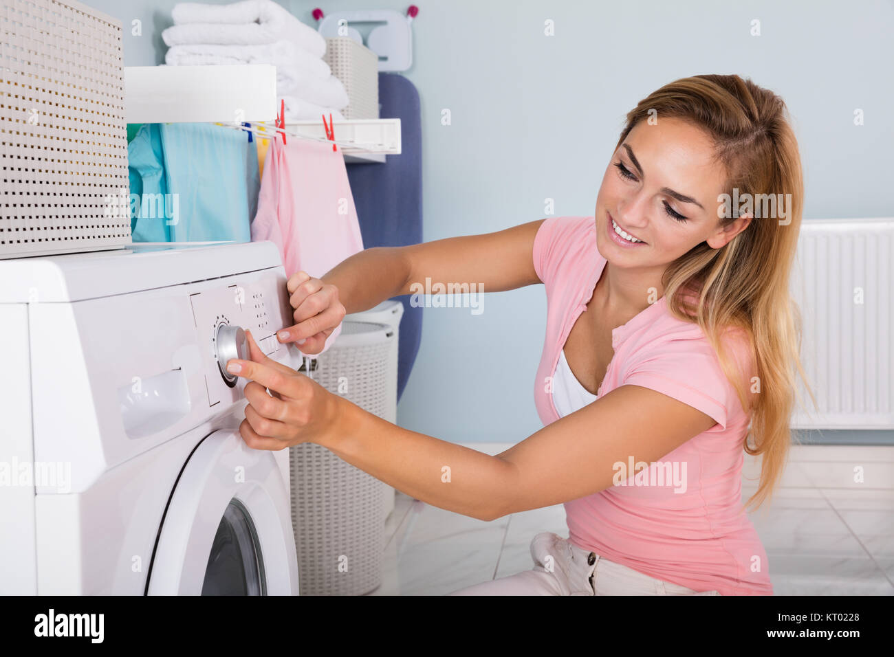 Woman Using Washing Machine In Utility Room Stock Photo - Alamy
