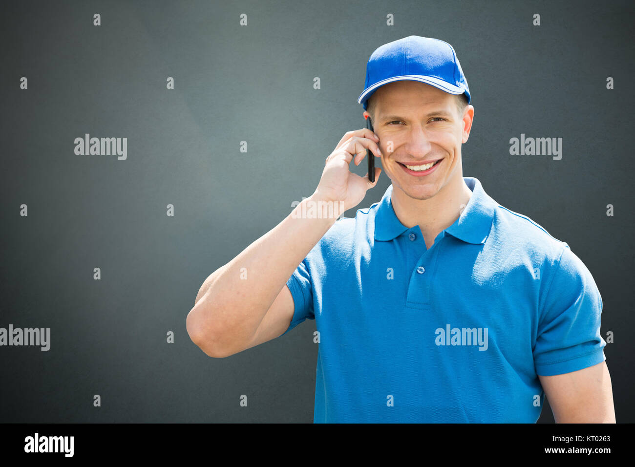 Happy Delivery Man Using Cellphone Stock Photo - Alamy