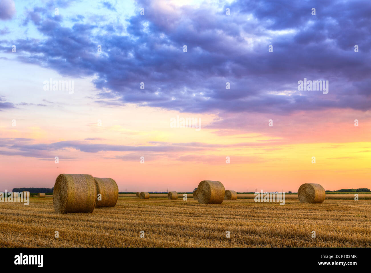 Sunset over farm field with hay bales Stock Photo - Alamy