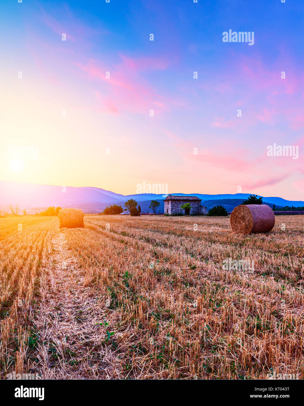 Sunset over farm field with hay bales near Sault Stock Photo - Alamy