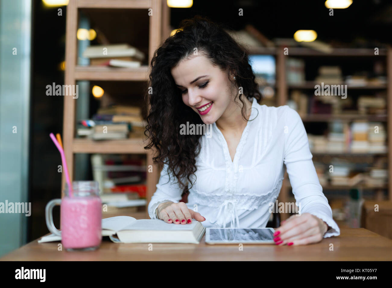Young woman reading book in coffee shop Stock Photo - Alamy