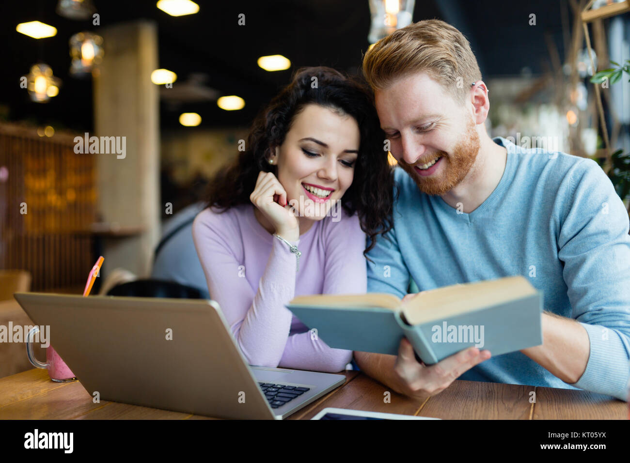 Young students spending time in coffee shop reading books Stock Photo ...