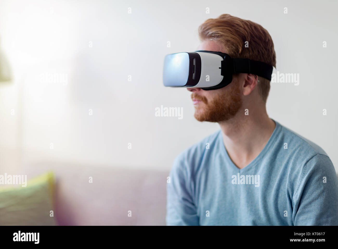 Man wearing virtual reality headset at home Stock Photo - Alamy