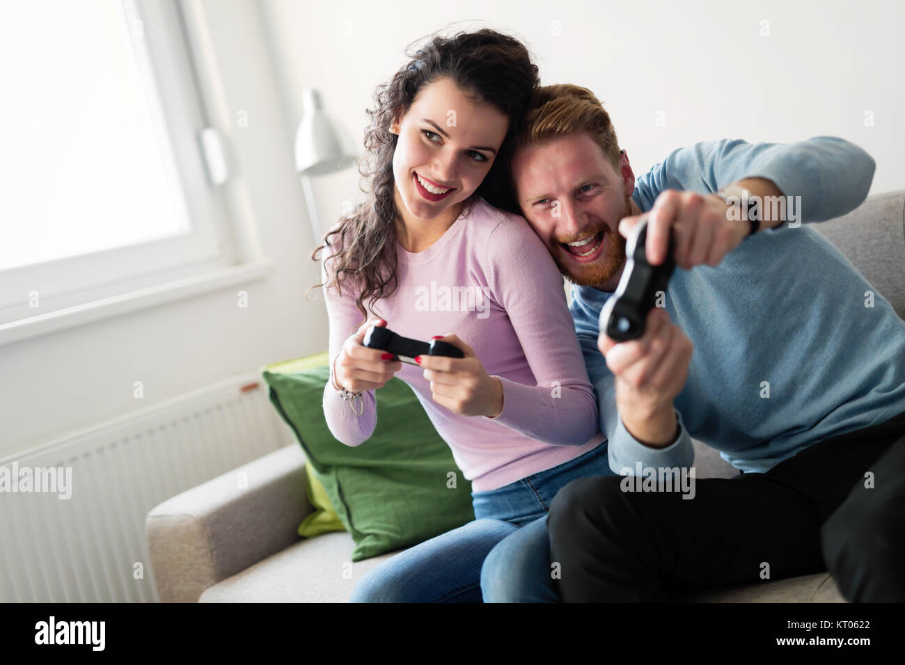 Happy couple playing video games at home Stock Photo - Alamy